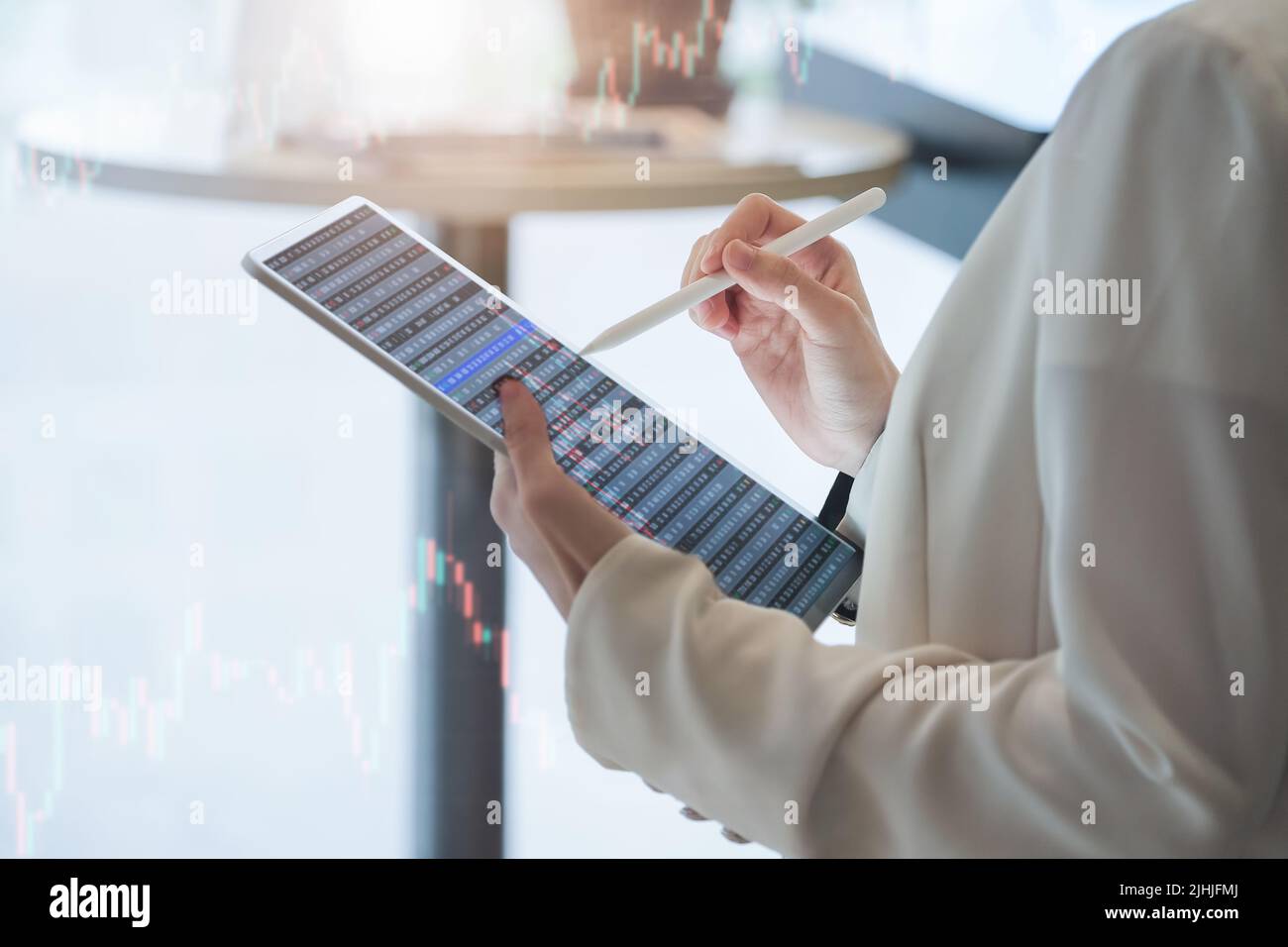 Business woman using tablet to trade charts to find buy and sell points ...