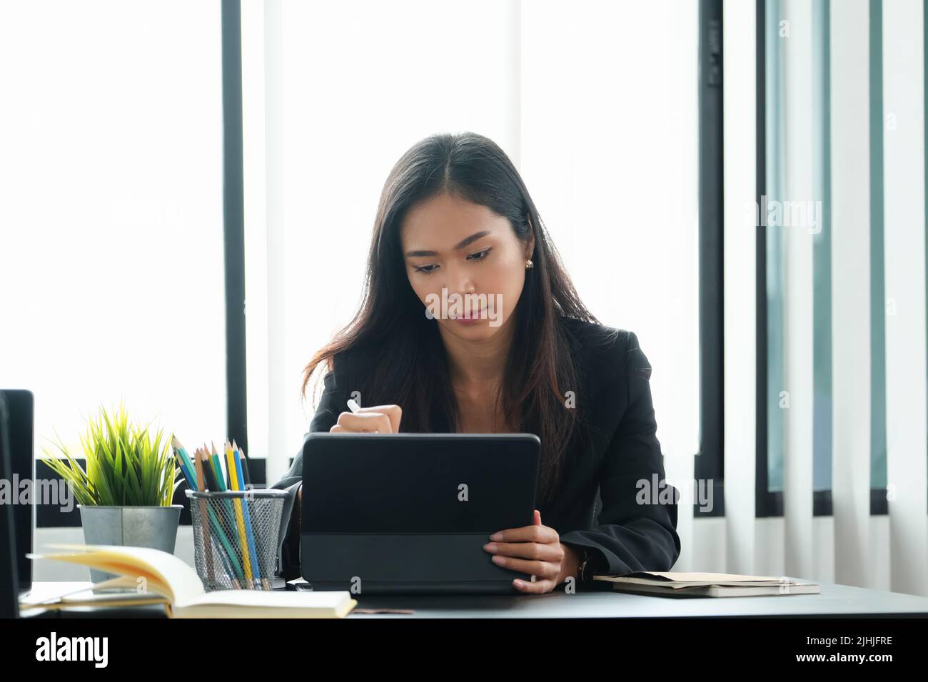 Business woman using tablet to review balance sheet annual using ...