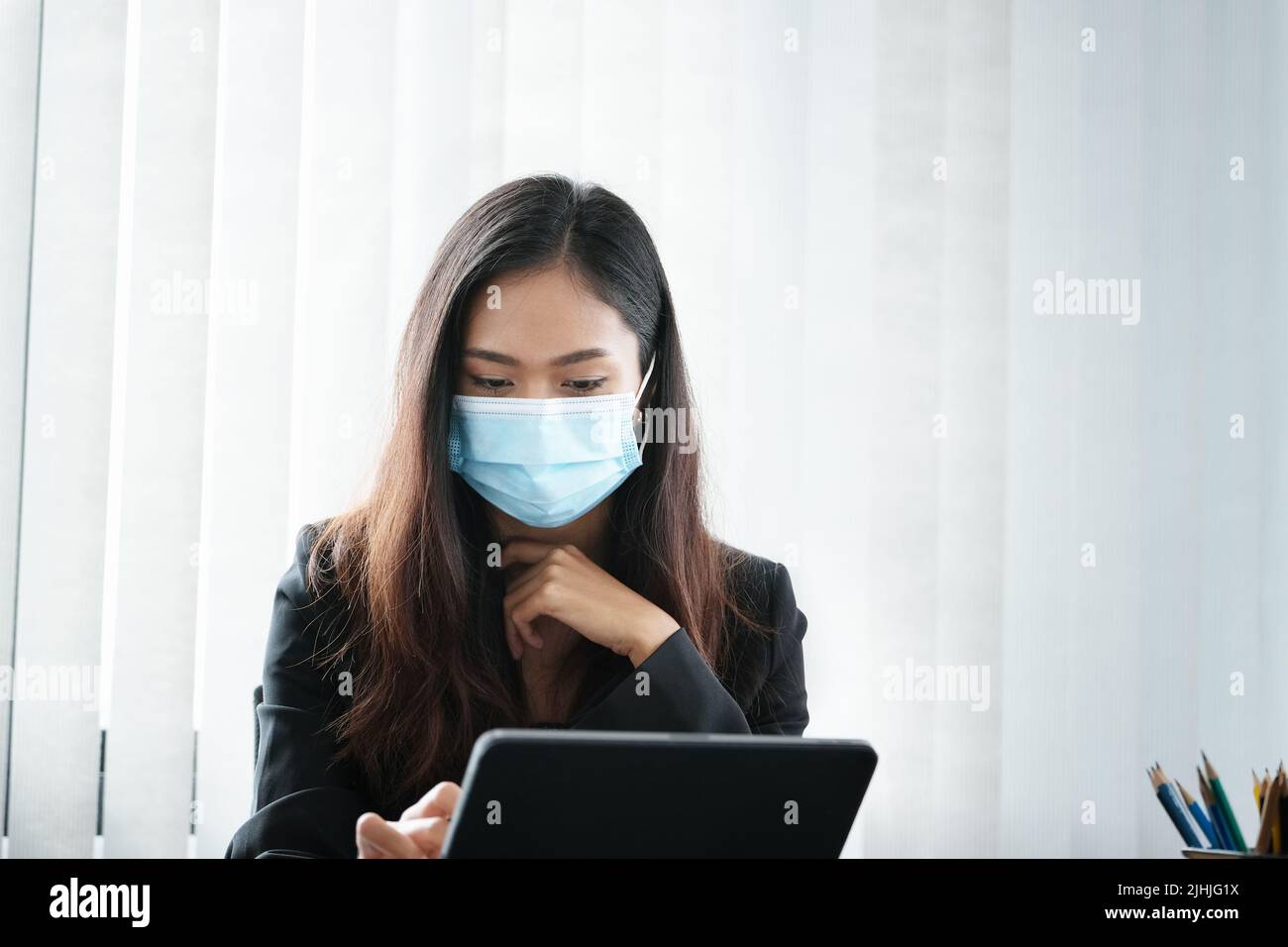 Business woman using tablet to review balance sheet annual using ...