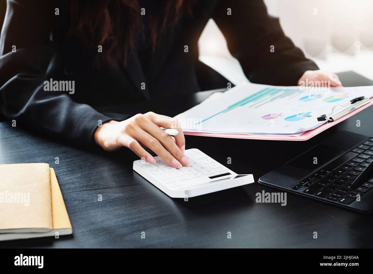 Business woman using calculator to review balance sheet annual using ...