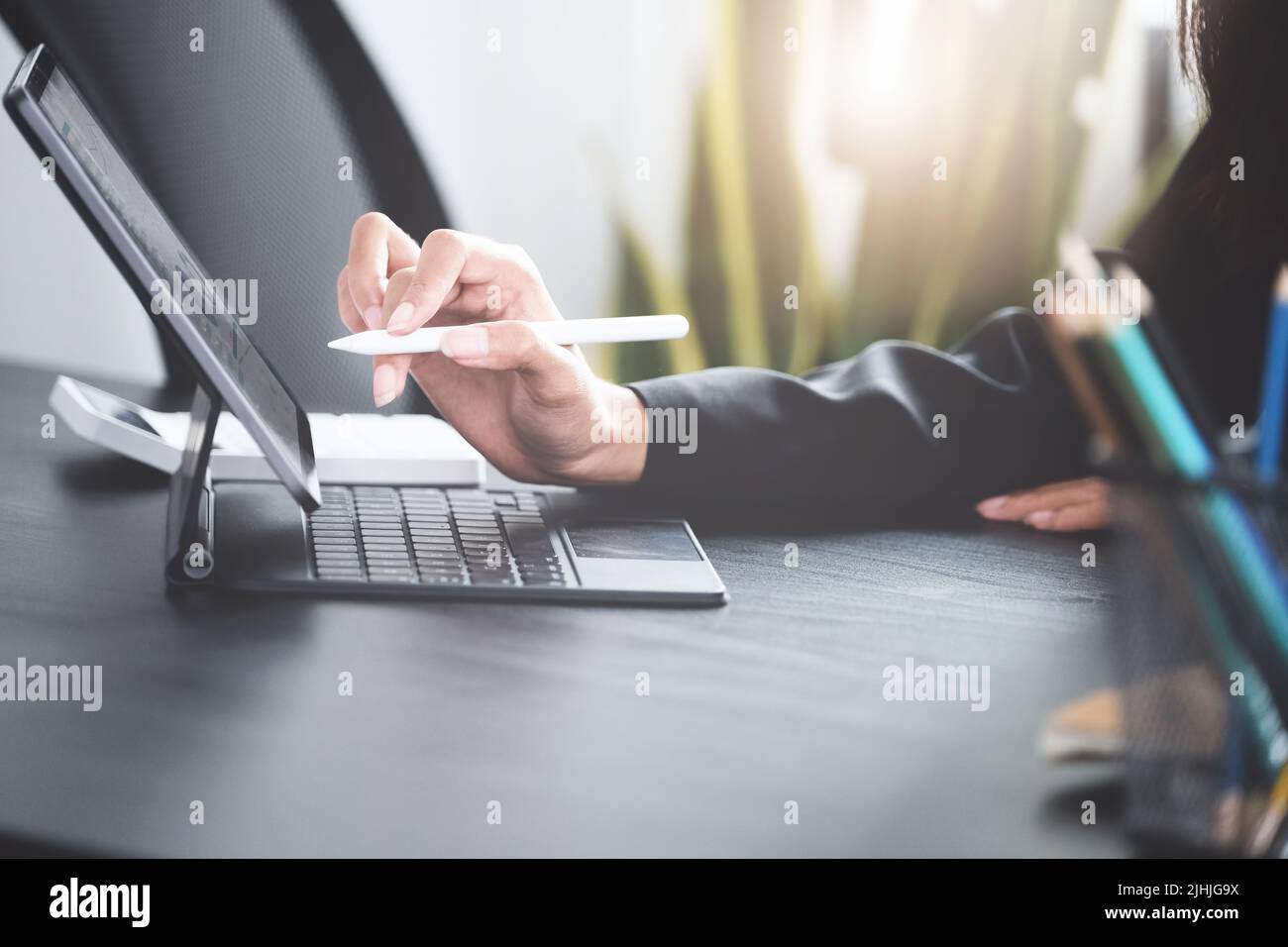 Business woman using tablet to review balance sheet annual and ...
