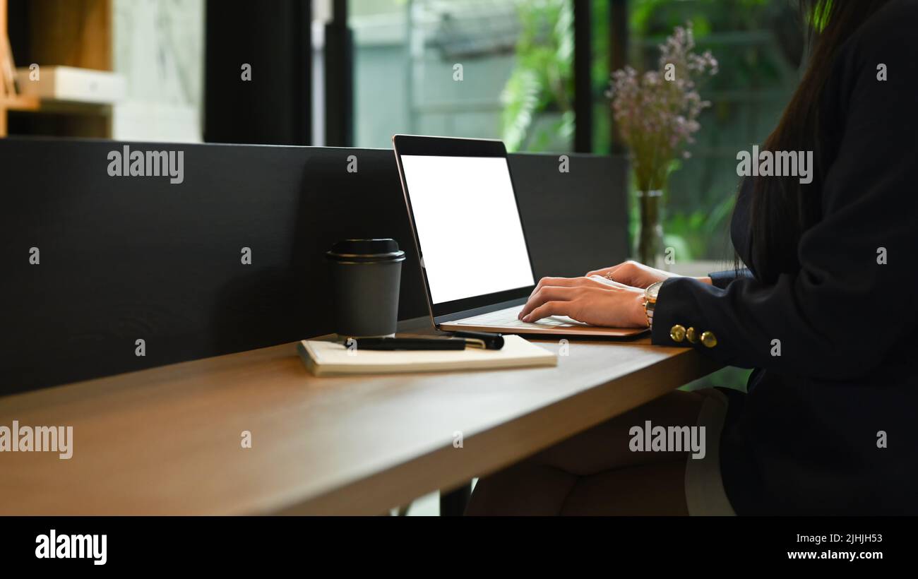 Side view young woman office worker using laptop at wooden counter bar ...