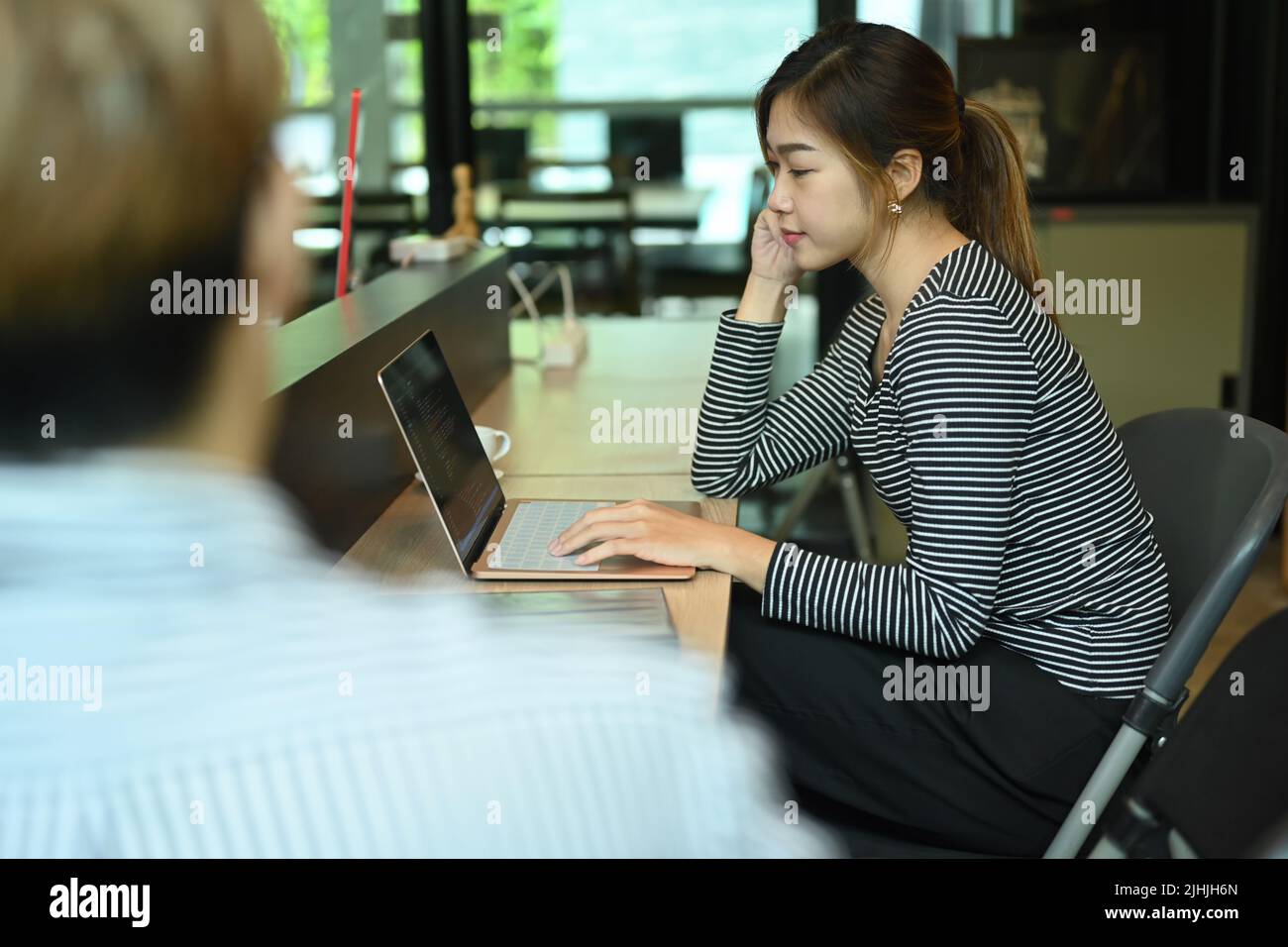 Website developer team programming code on computer screen and brainstorming for new project at ...