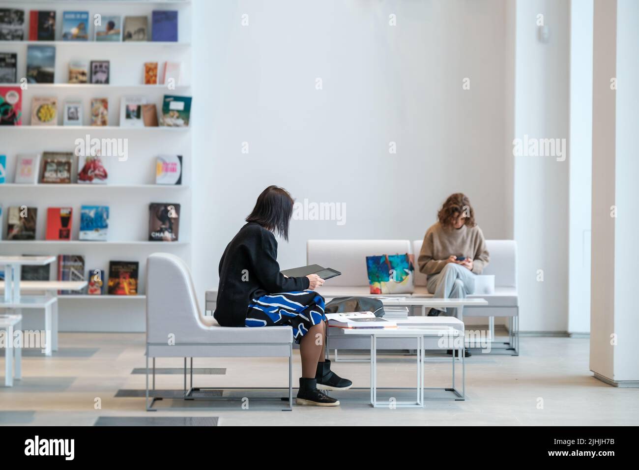Women using devices in library Stock Photo - Alamy