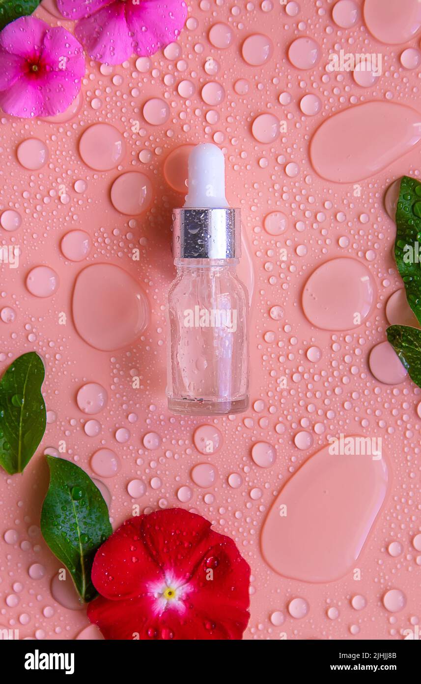 Background with water drops cosmetics in a bottle and flowers ...