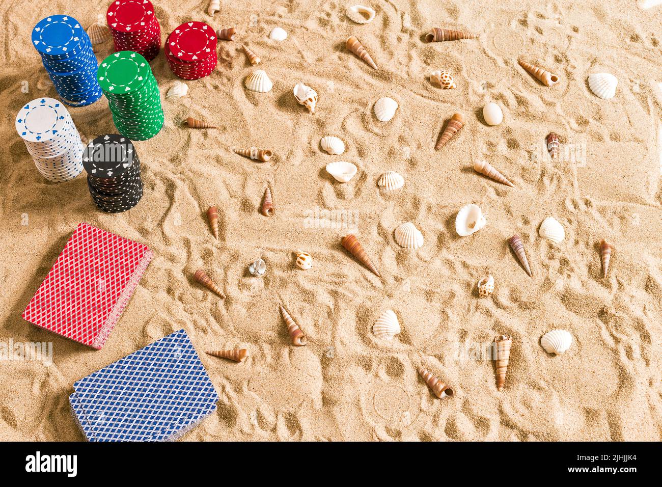 Beachpoker. Chips and cards on the sand with seashells. Top view Stock ...