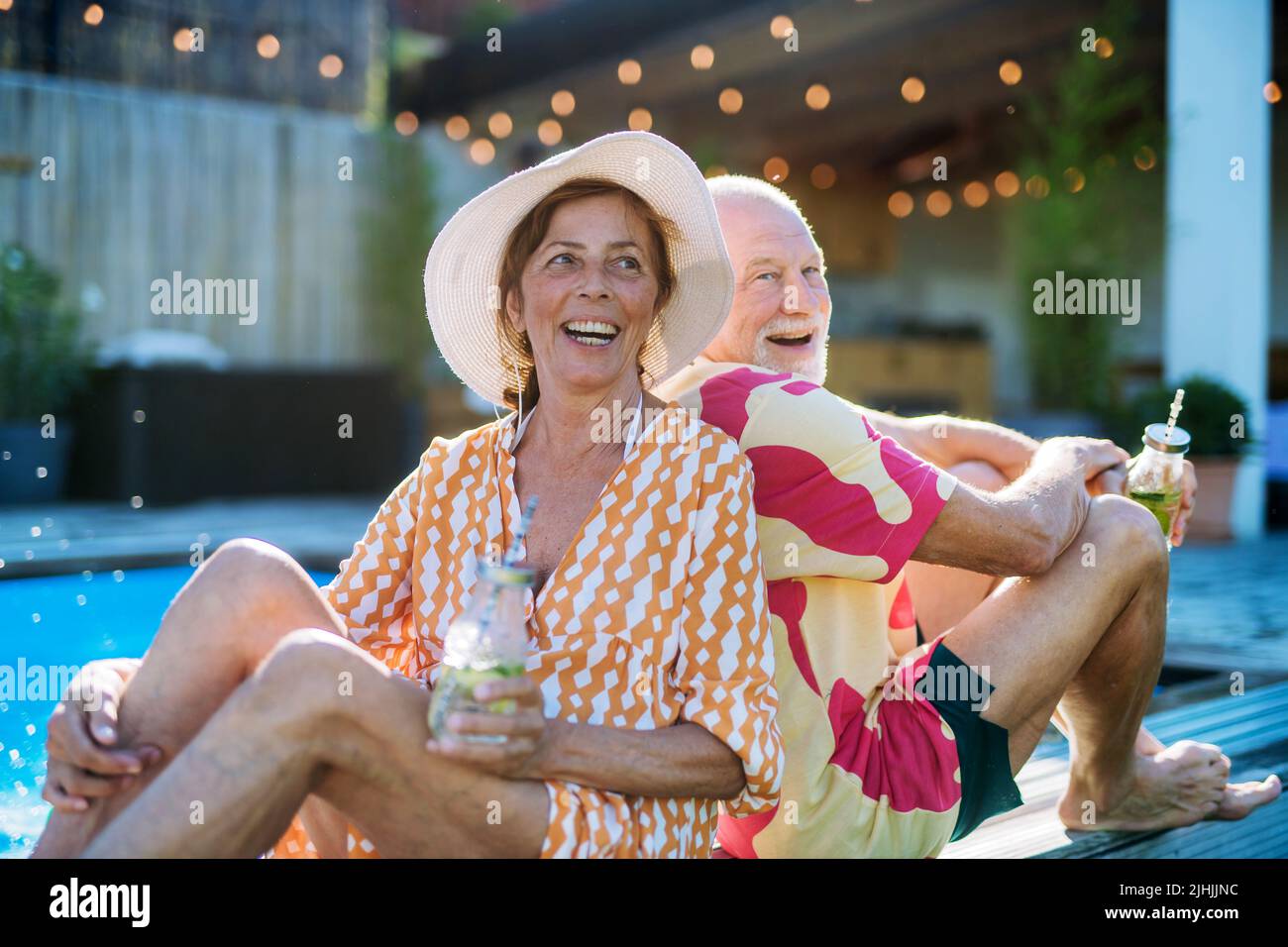 Happy Senior Couple Enjoying Drinks When Relaxing And Sitting By