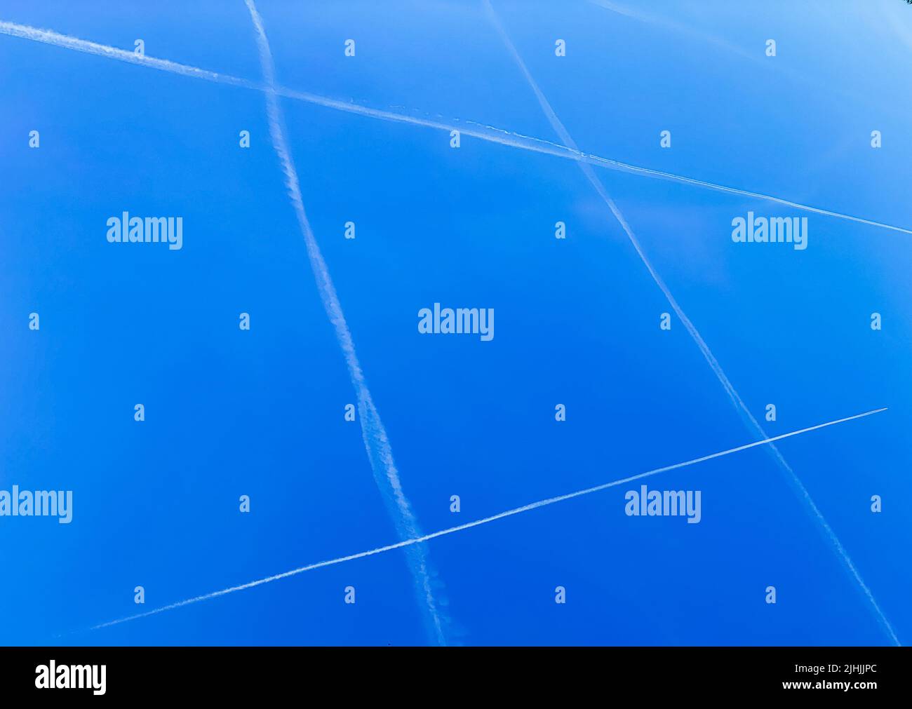Many contrails cross each other in the blue sky Stock Photo - Alamy