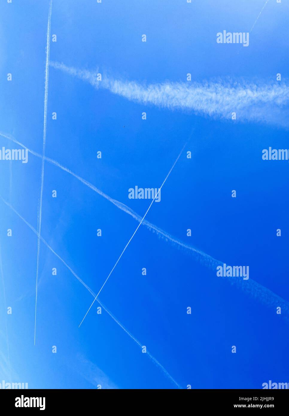 Many contrails cross each other in the blue sky Stock Photo - Alamy