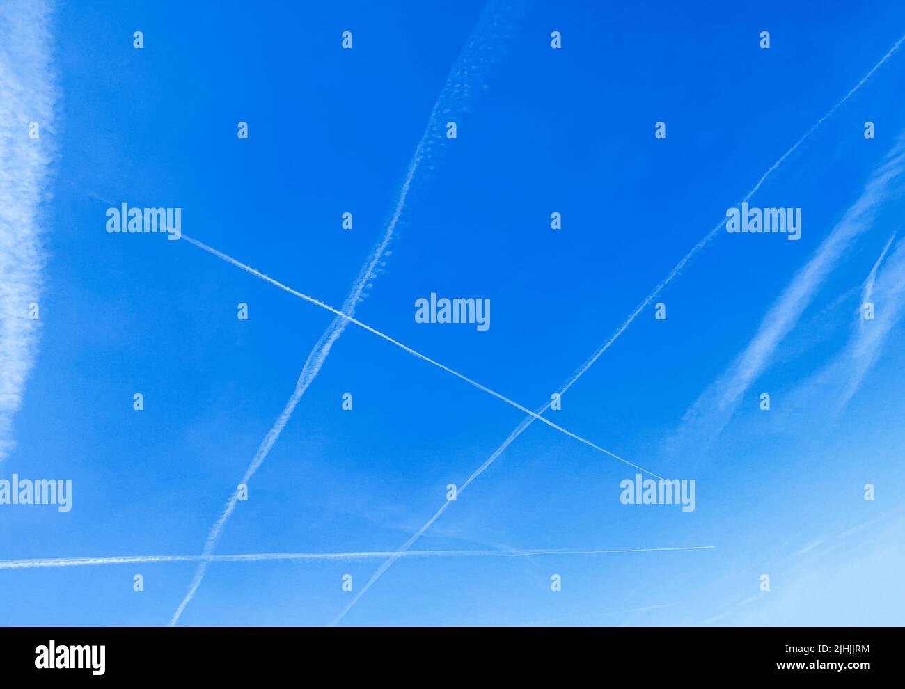 Many contrails cross each other in the blue sky Stock Photo - Alamy