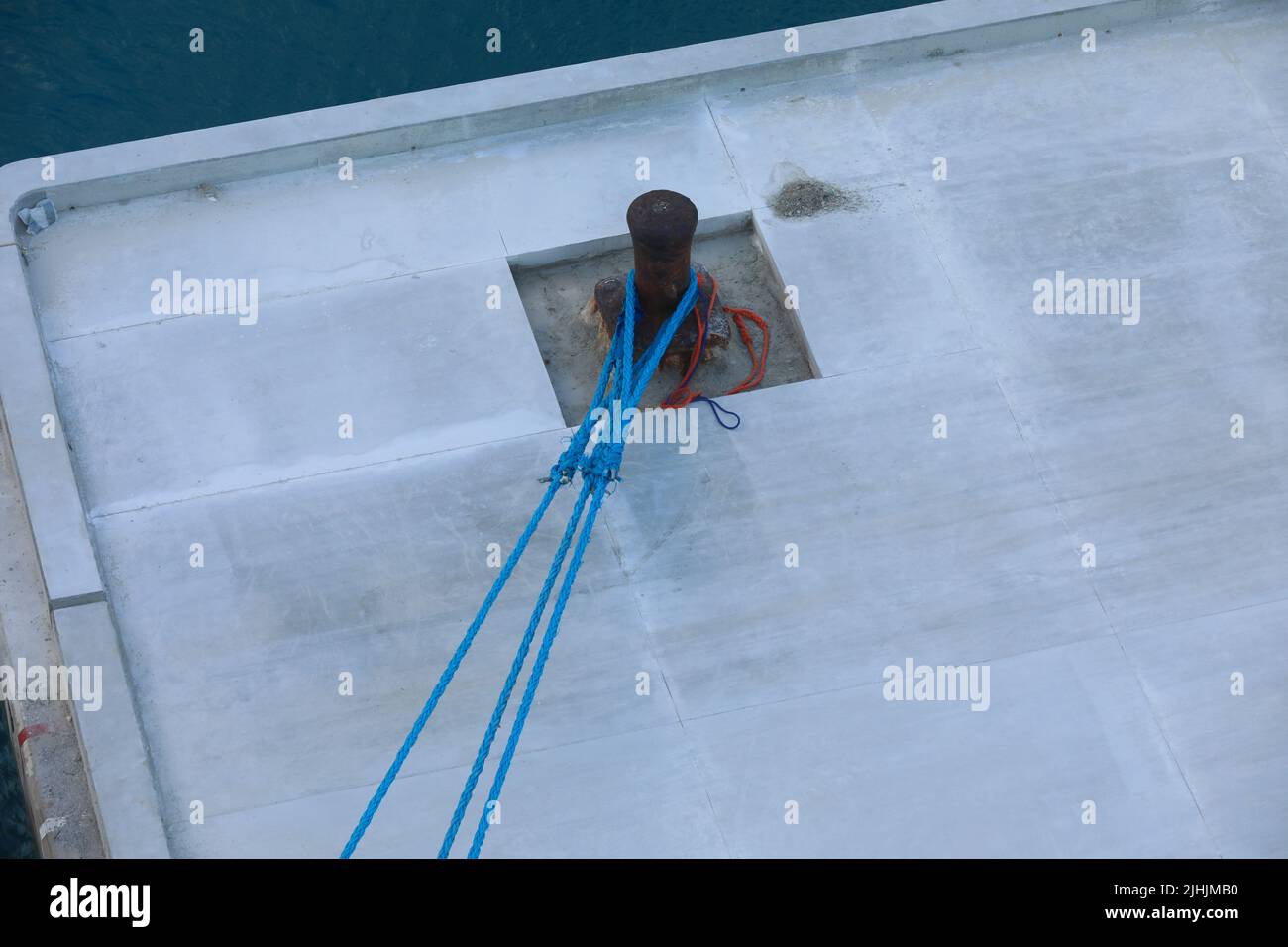 blue Mooring rope and bollard on sea water Stock Photo - Alamy