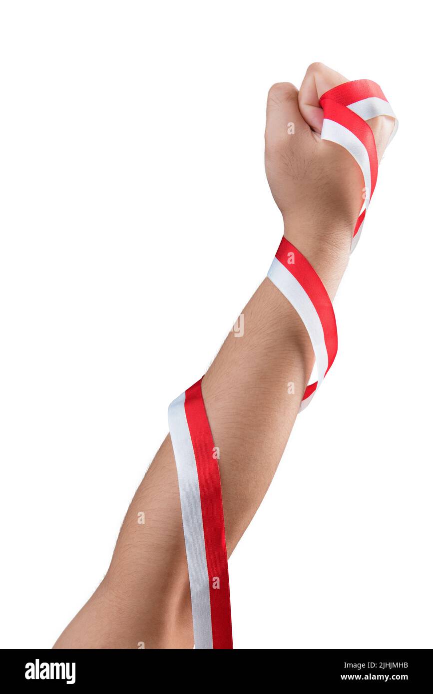 Human hand holding a ribbon with the red and white color of the ...