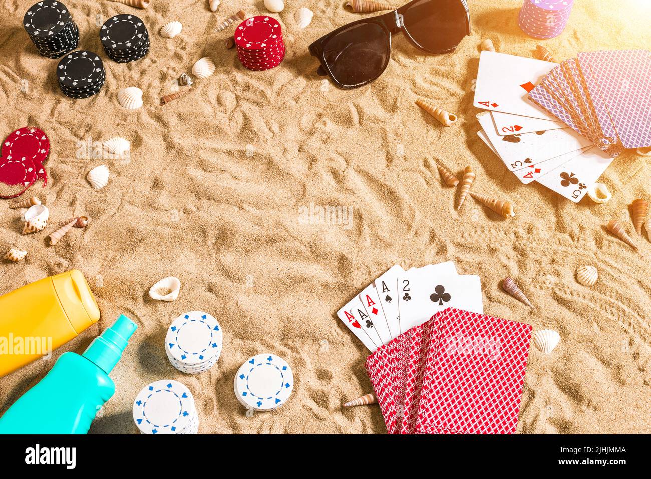 Beachpoker. Chips and cards on the sand. Around the seashells ...