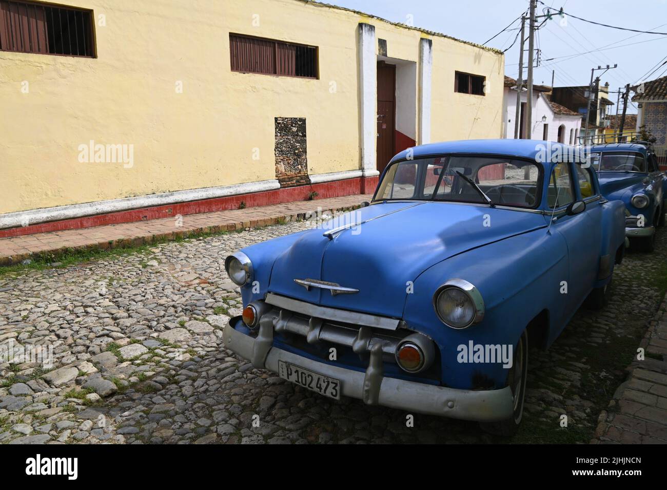 Blue vintage car on the cobblestone streets with the old Colonial ...