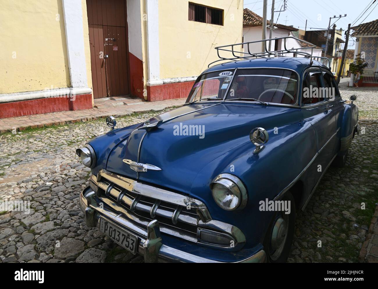 Blue vintage car on the cobblestone streets with the old Colonial ...