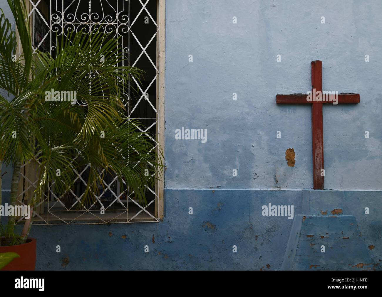 Handcrafted wooden cross on a weathered light blue stucco wall in ...