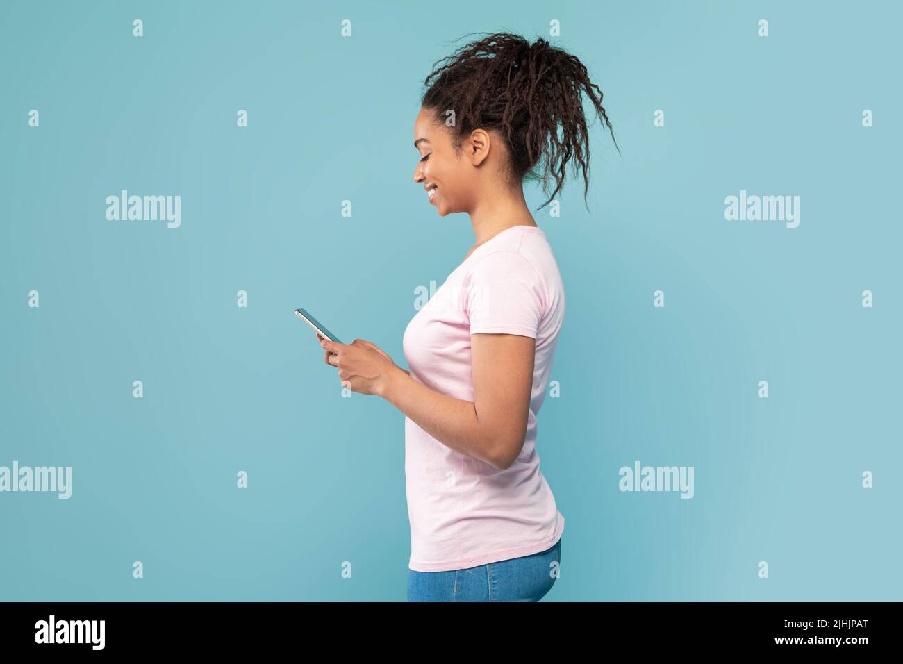 Profile portrait of black lady using smartphone, typing sms message ...