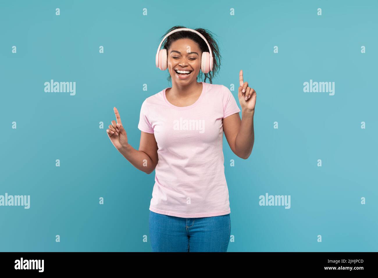 Happy african american woman in wireless headphones listening to ...