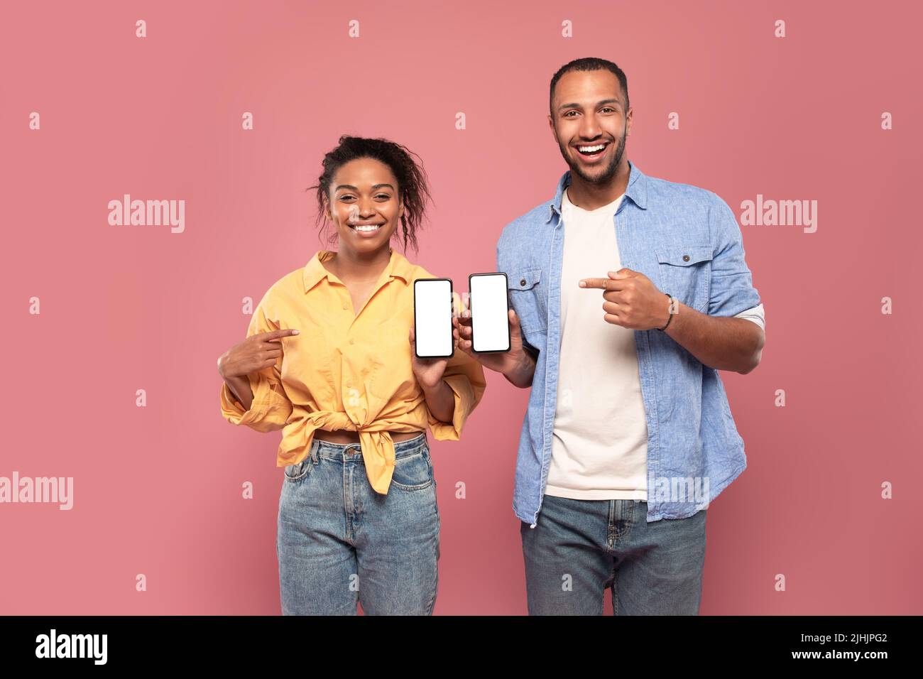 Use this new application. Happy black couple holding 2 smartphones in ...