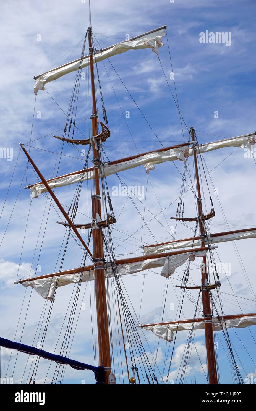 Tall ship mast with rolled sails, sky in background Stock Photo - Alamy