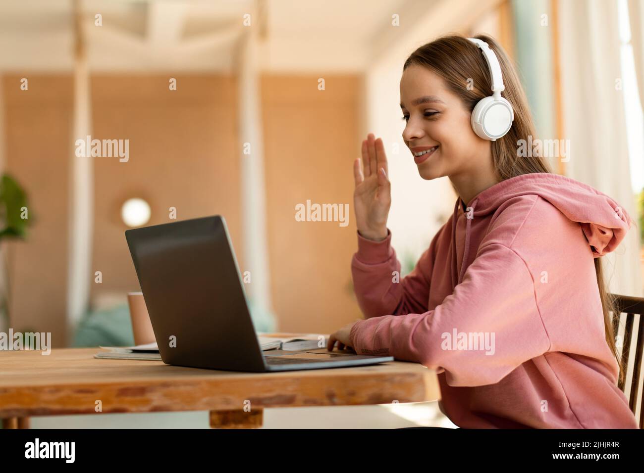 Excited girl teenager having video call with teacher from home, using ...