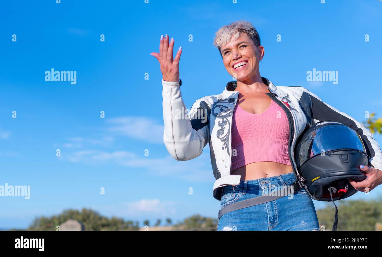 young pretty blonde woman with short hair dressed as a biker with a ...