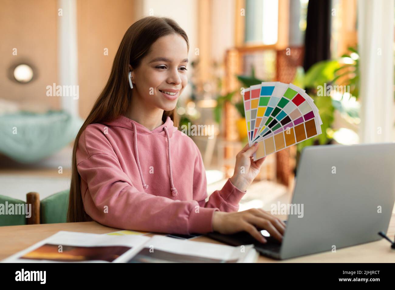 Excited teen girl designer sitting at desk and having online lesson via ...