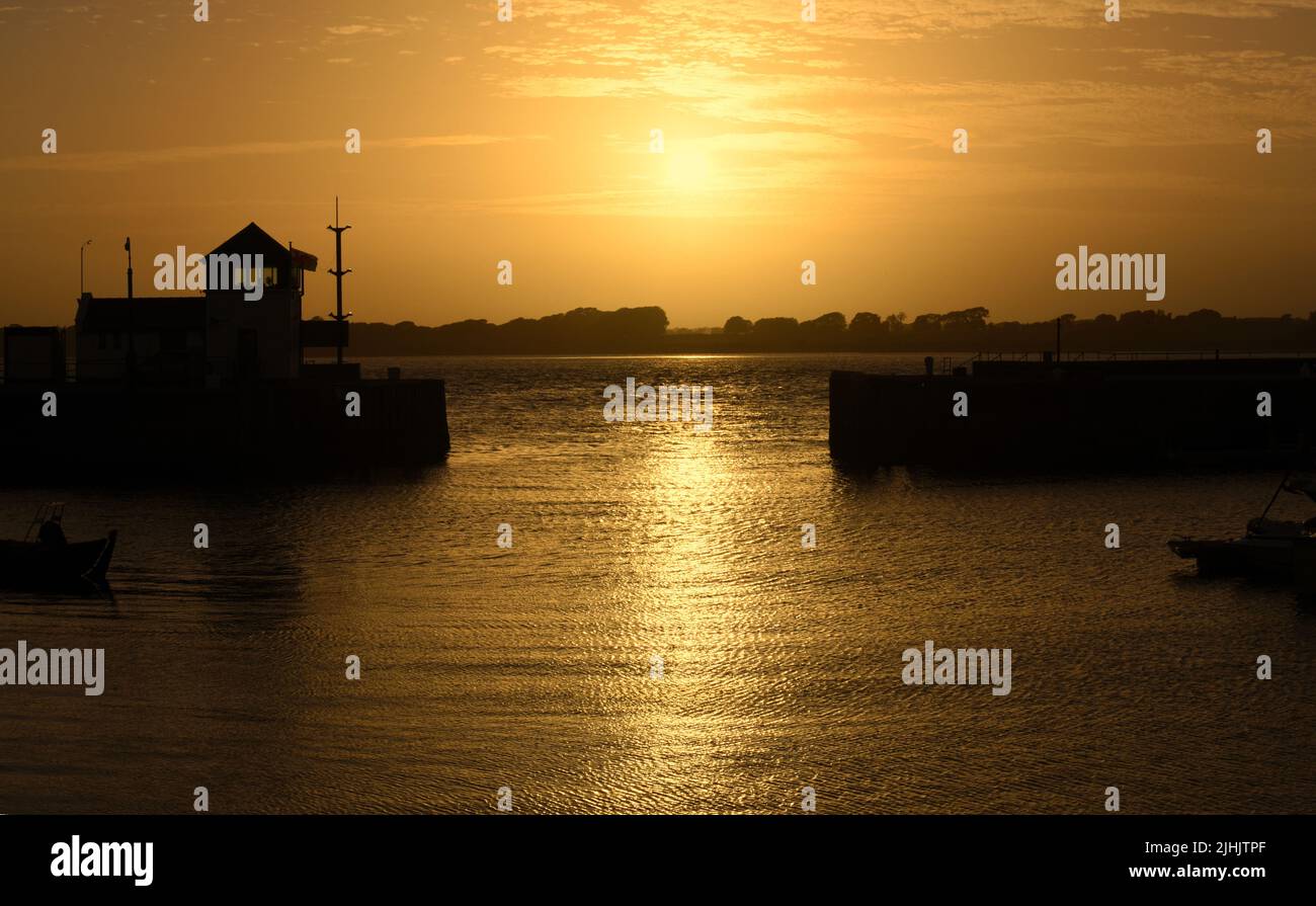 Orange skies over water at the end of a beautiful summer's day in ...