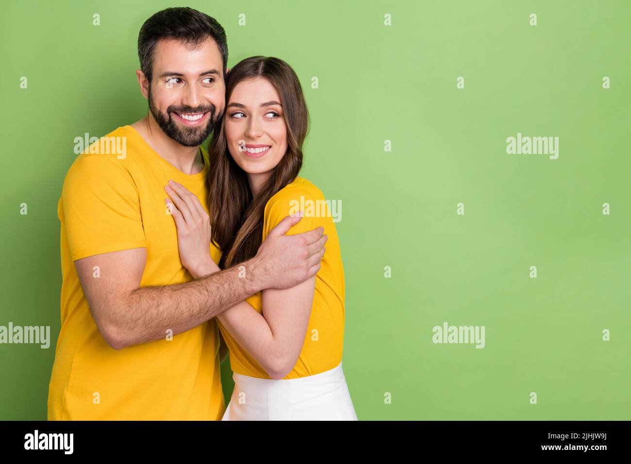 Portrait of two positive lovely partners hugging look empty space ...