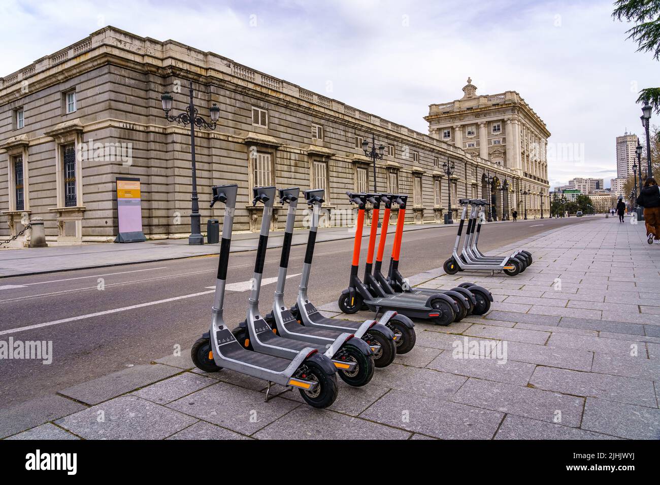 electric scooters parked in a street in the royal palace of madrid ...