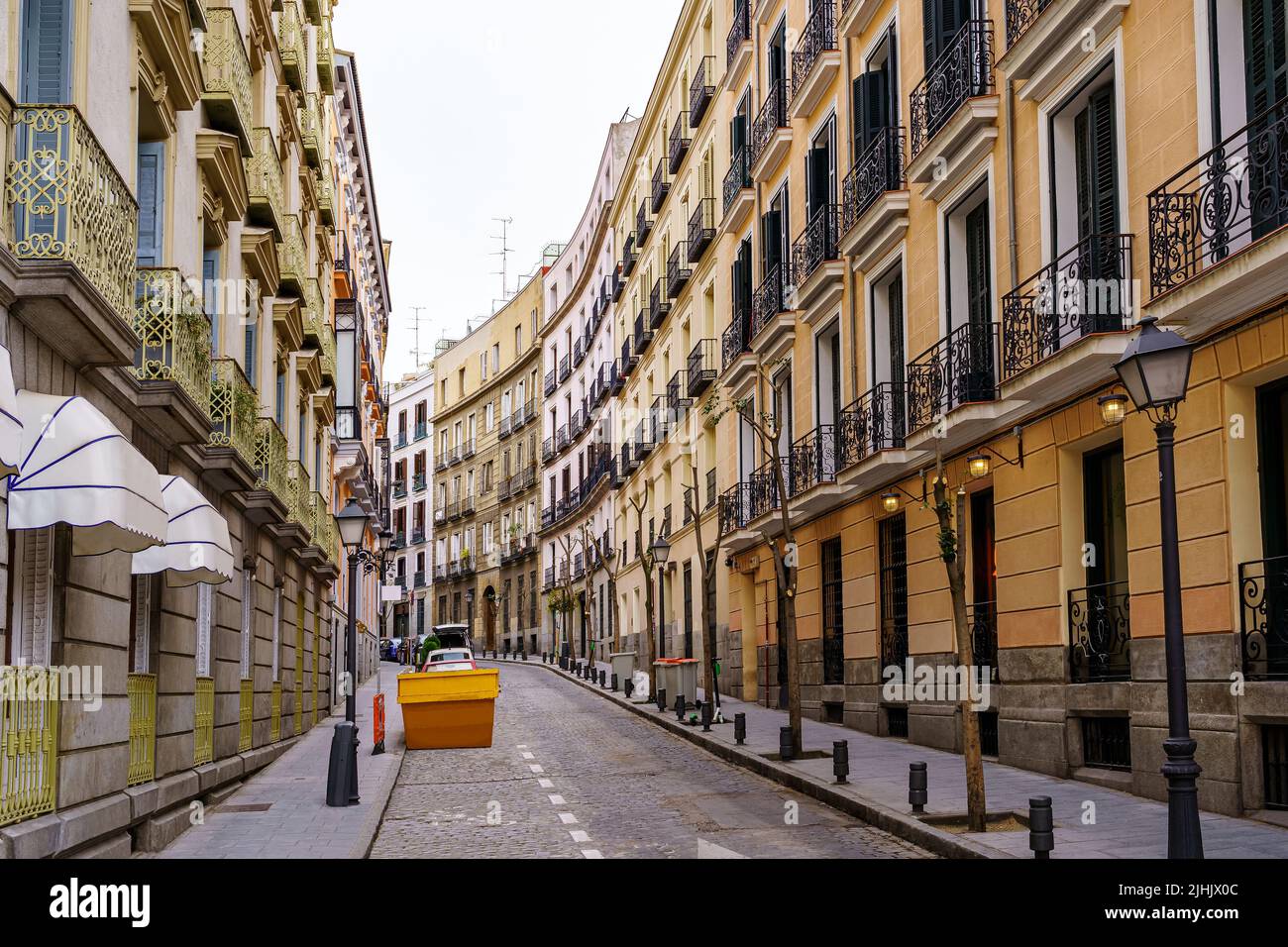 Narrow street in Madrid with typical balconies of the city and colored ...