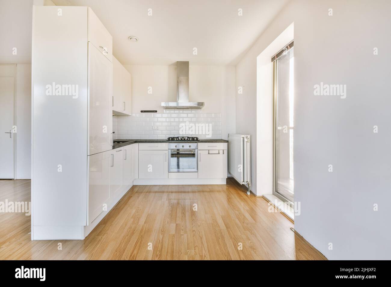 Interior of empty white kitchen with corridor and wooden parquet floor ...