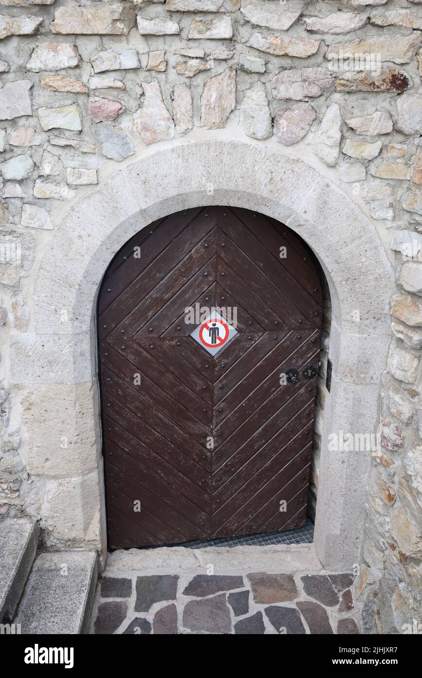 "No entry" pictogram sign on a wooden door in a stone wall Stock Photo ...