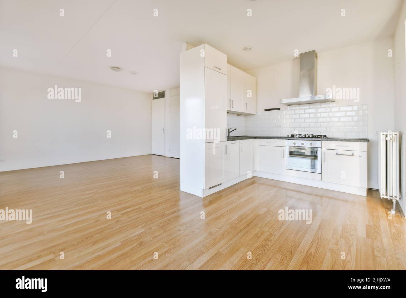 Interior of empty white kitchen with corridor and wooden parquet floor ...