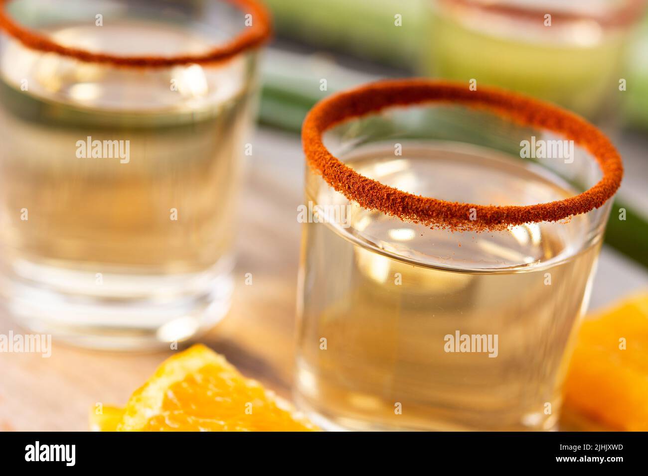 Mezcal Mexican drink with orange slices and worm salt on wooden table ...