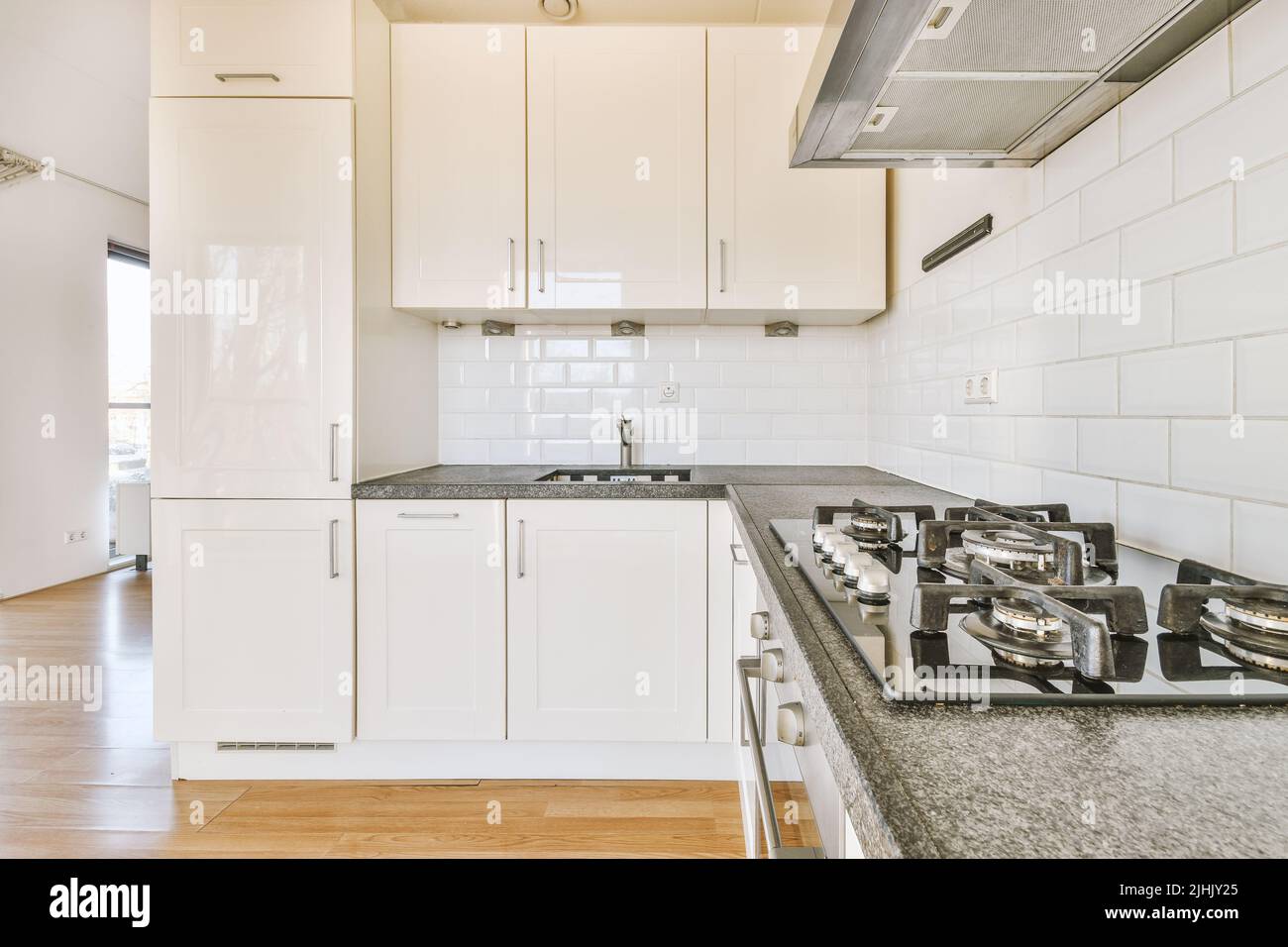 Interior of empty white kitchen with corridor and wooden parquet floor ...