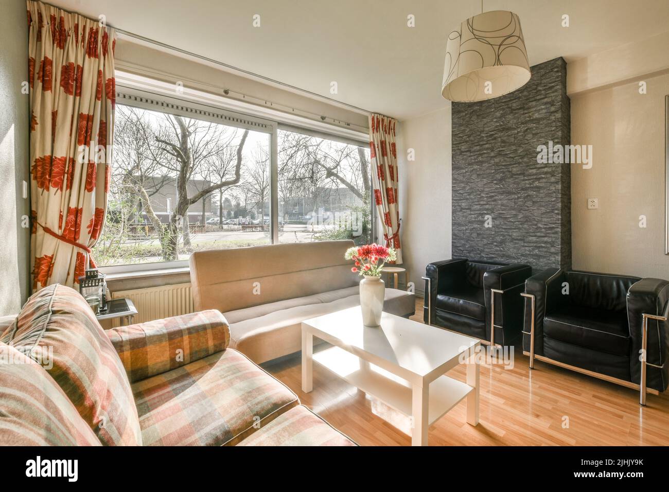 Simple expensive interior of living room with sofa near big window ...