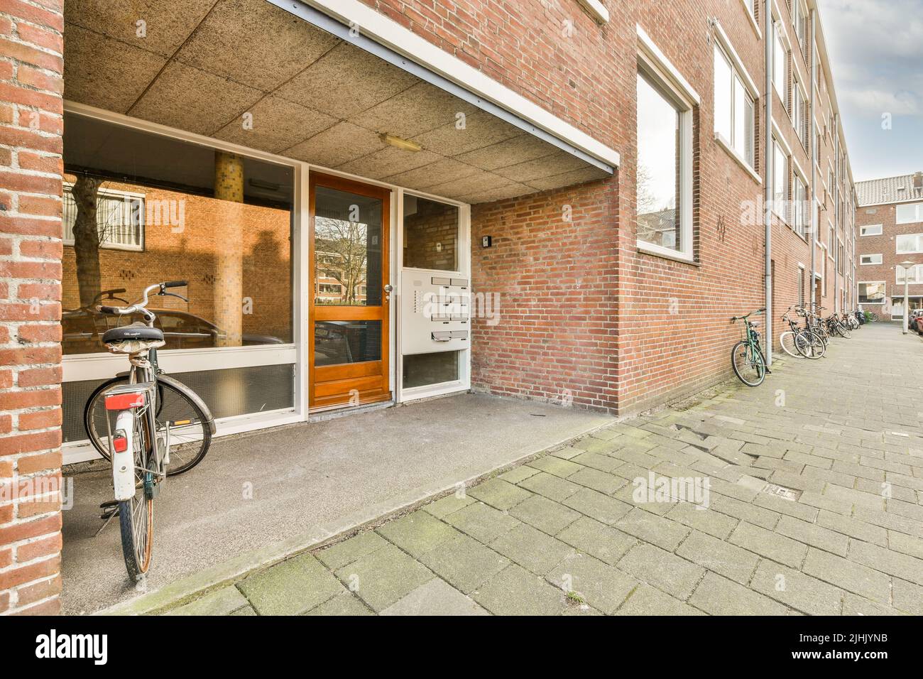 The front view of a brick building with signs, pavement and wooden ...