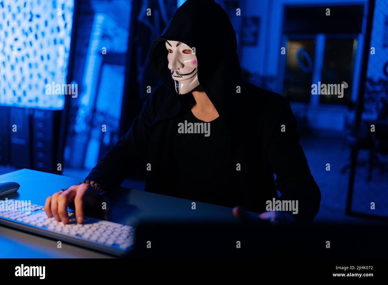 Wanted hacker man wearing in anonymous mask engaged in hacking into ...