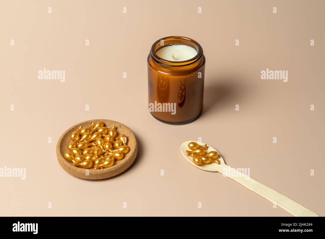 A face serum or oil in golden capsules lying on a beige background ...