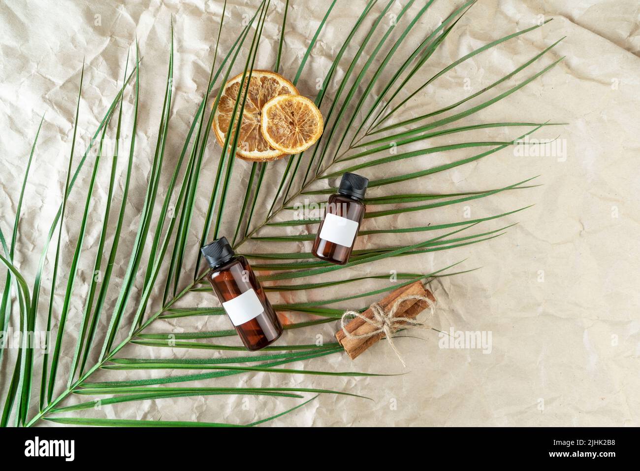 A face serum or essential oil with blank labels on them lying on a ...