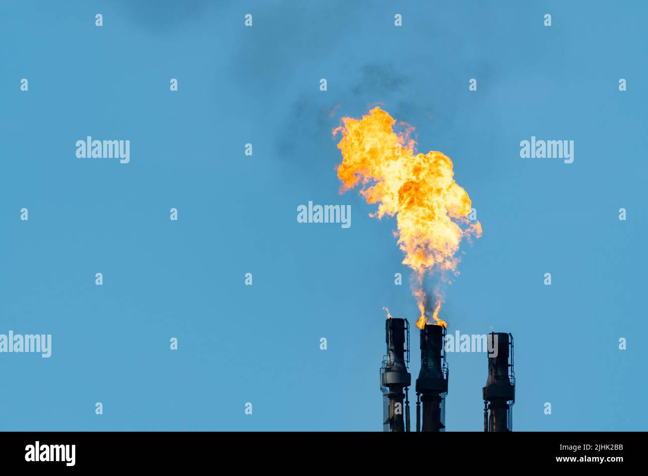 Oil refinery gas flare, flare stack burning off excess gas. Copy space ...