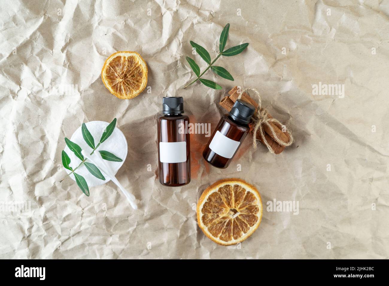 A face serum or essential oil with blank labels on them lying on a ...