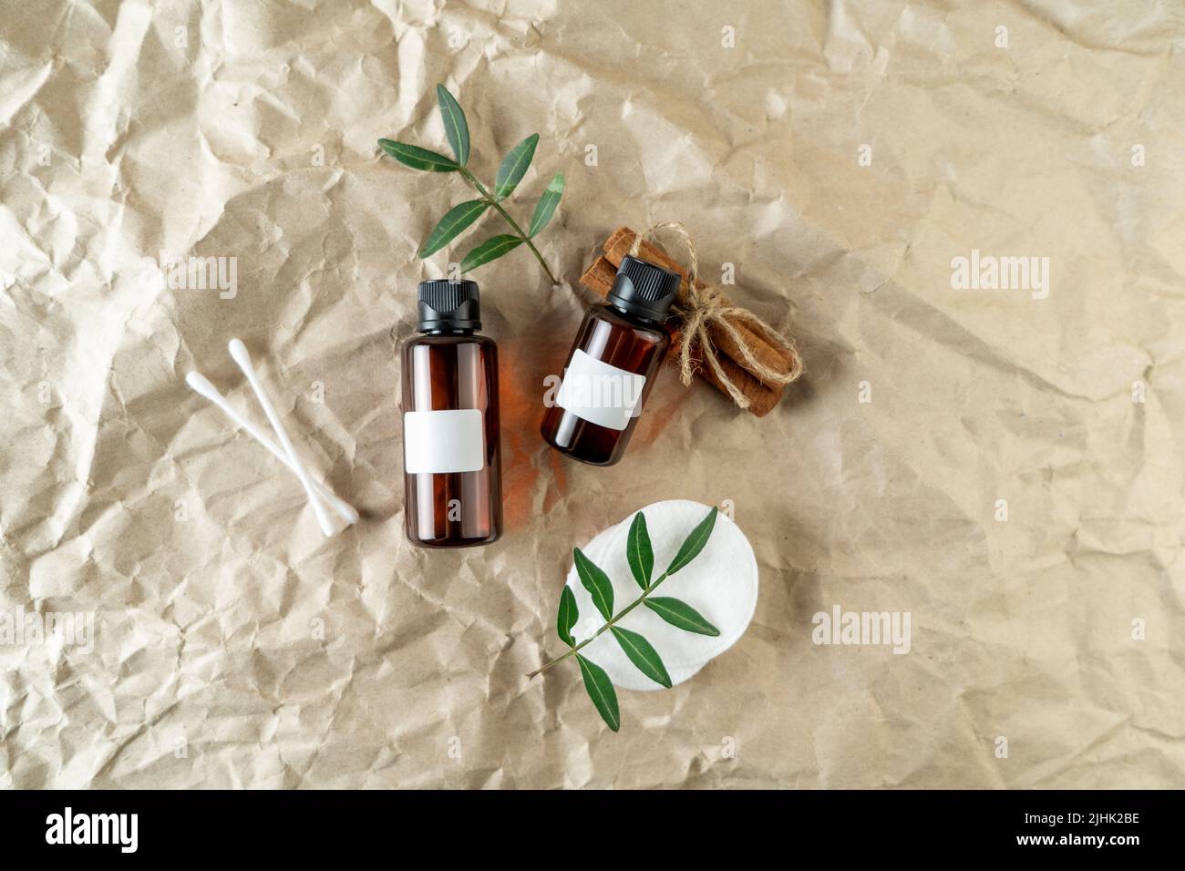 A face serum or essential oil with blank labels on them lying on a ...
