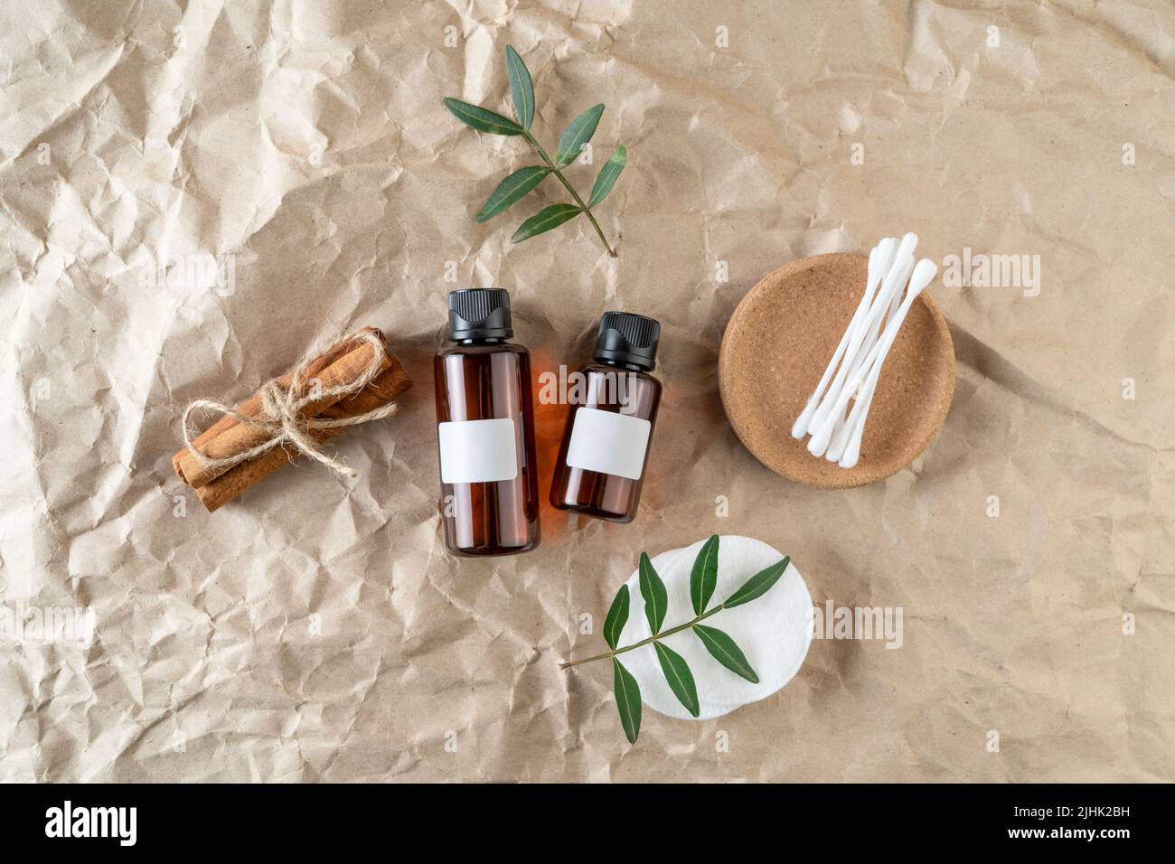 A face serum or essential oil with blank labels on them lying on a ...