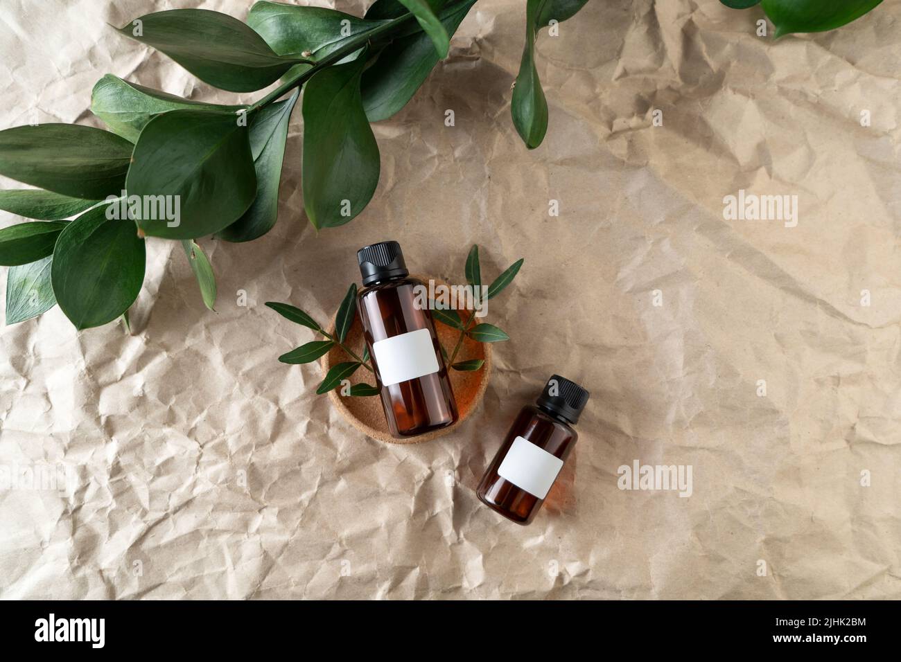 A face serum or essential oil with blank labels on them lying on a ...
