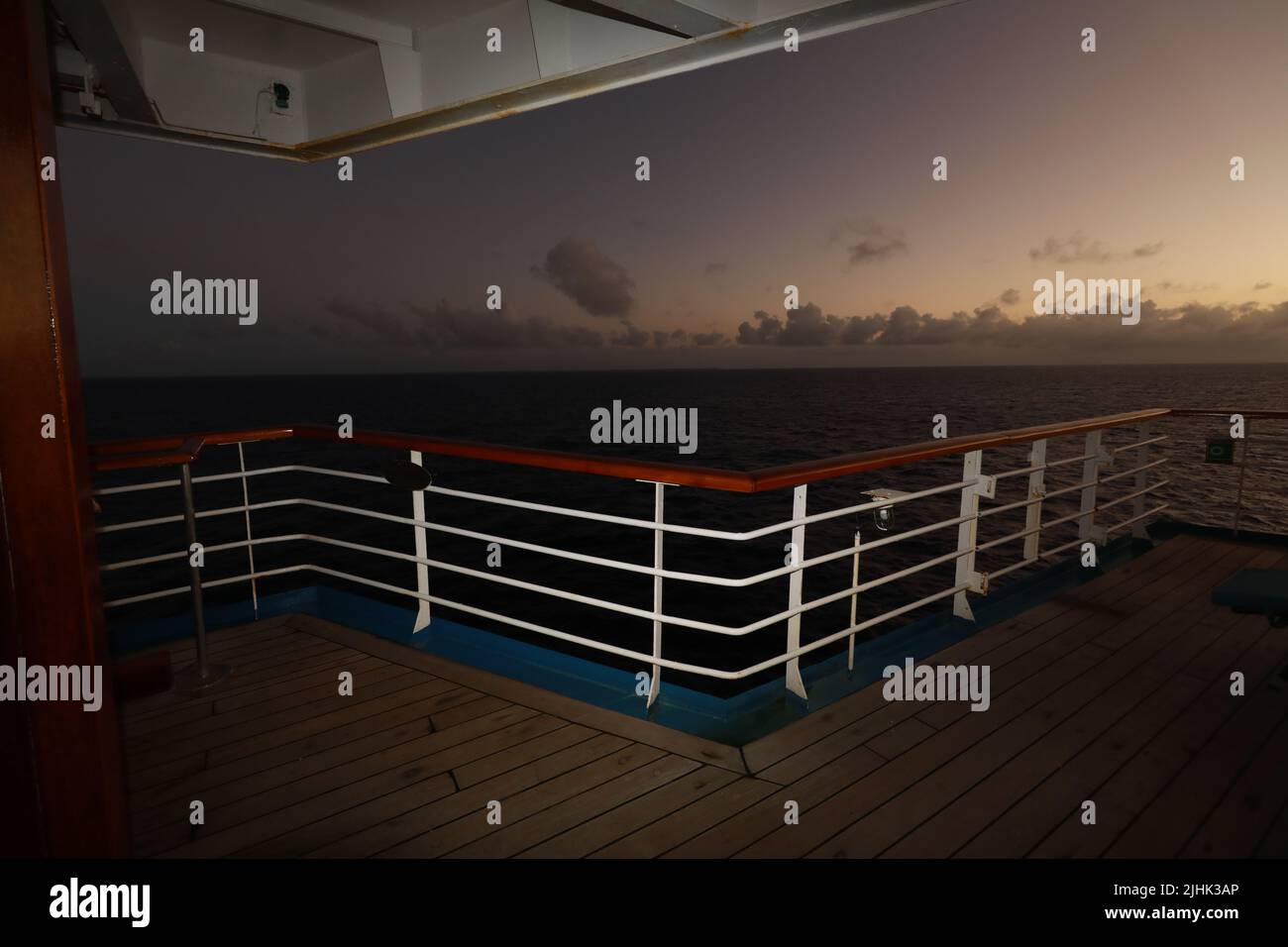 Wooden deck and railing from cruise ship. Beautiful sunset and ocean ...