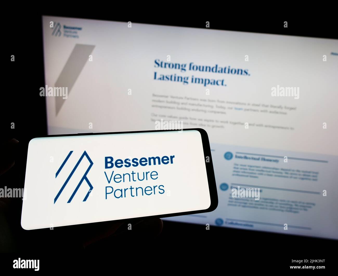 Person holding mobile phone with logo of American company Bessemer ...