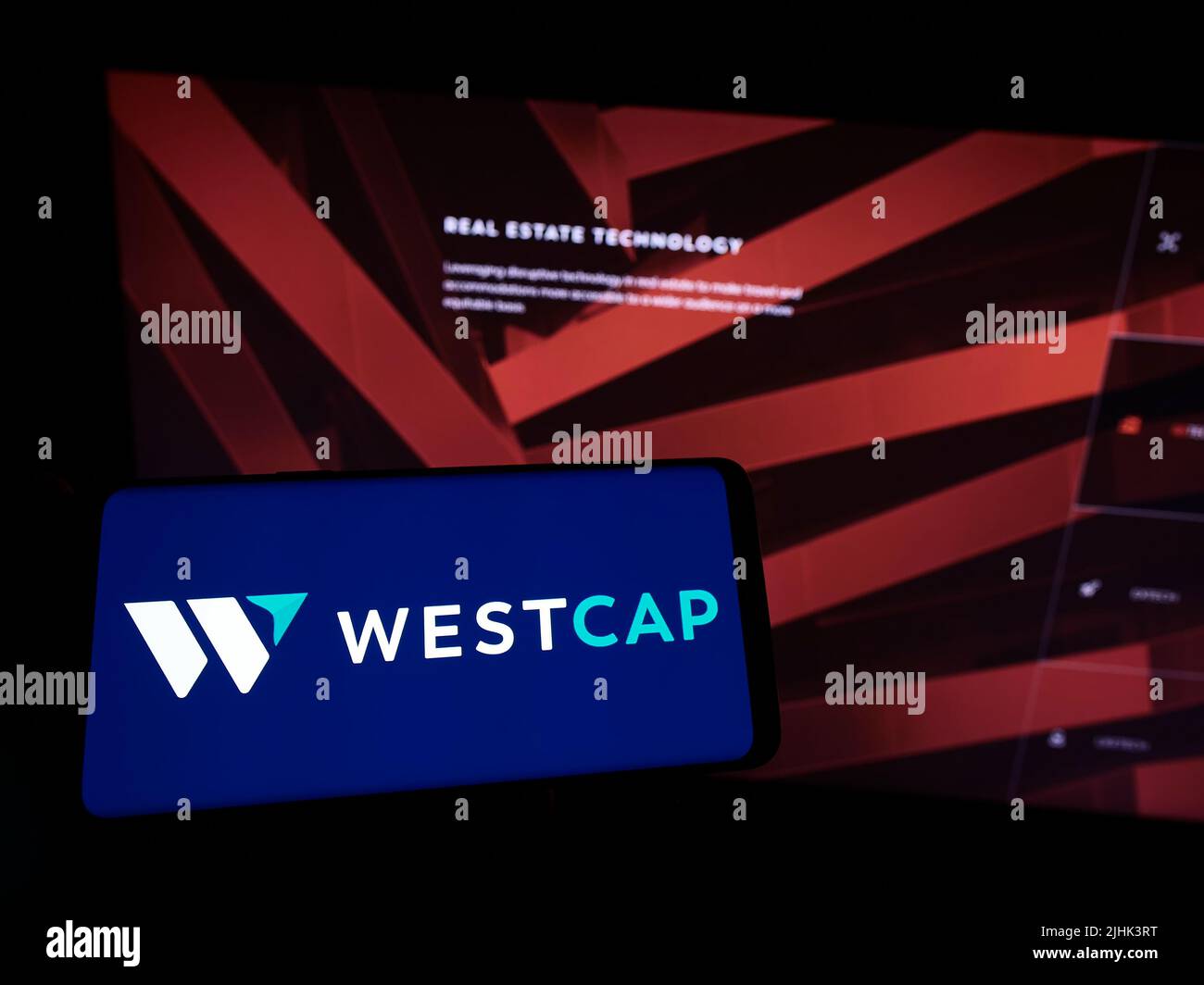 Person holding mobile phone with logo of American company Westcap ...