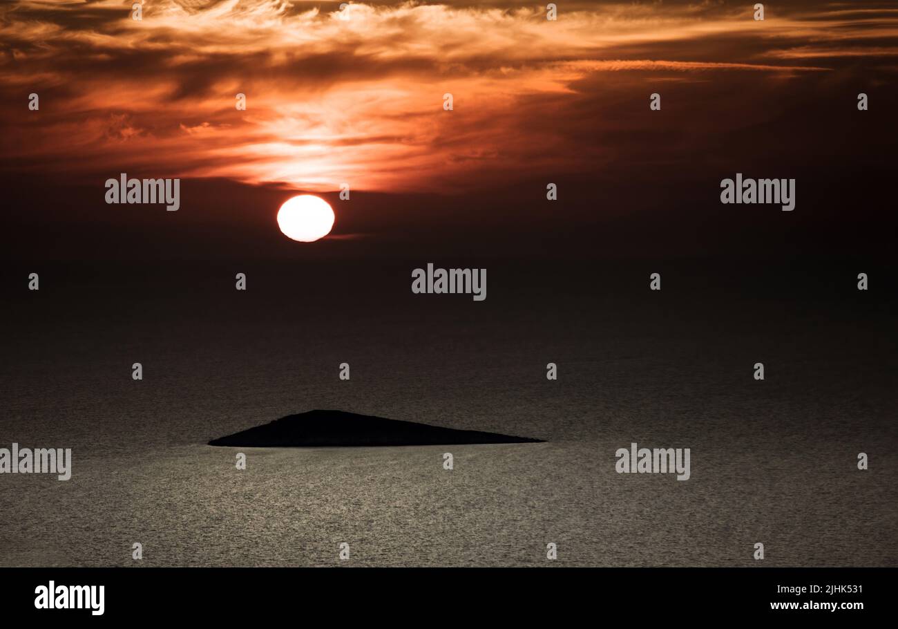 Powerful sunset with sun falling down into darkness with island ...